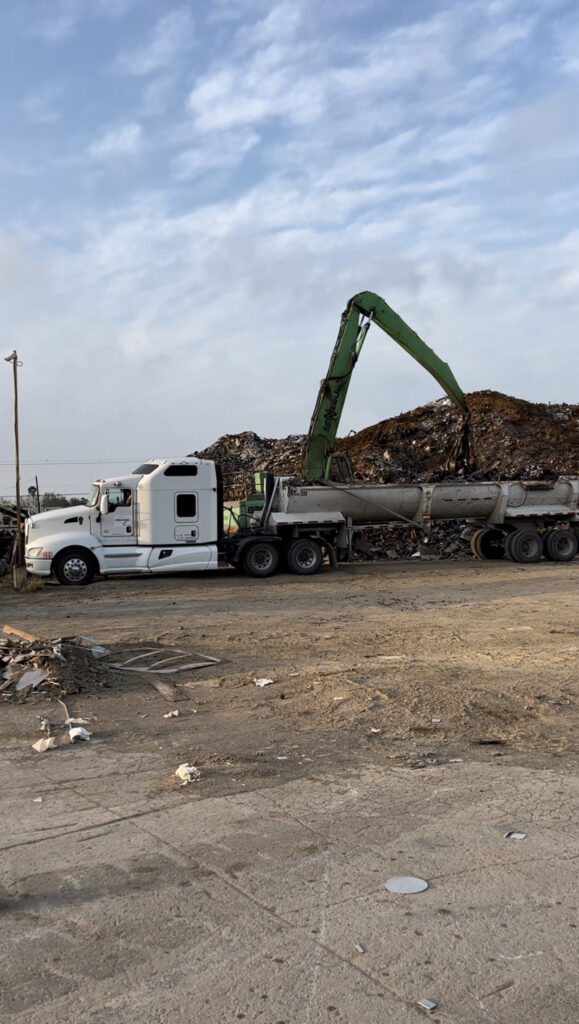 Loading scrap metal to take to a barge in the port. This scrap metal is ...